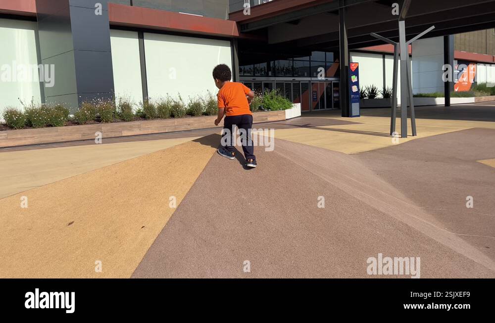 Persistent 3-year-old black child enjoying climbing and sliding in a ...