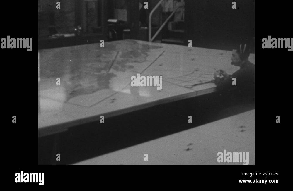 1940s: Radar control center. Men place objects on giant table map. Men ...