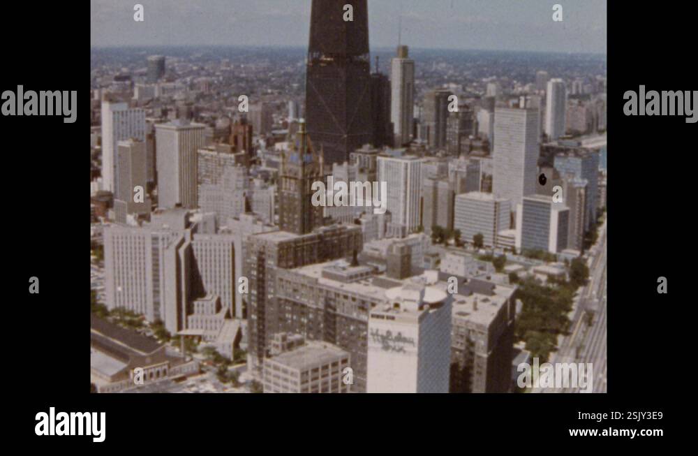 1980s: Chicago skyline. Waves crash on the shore near mountainous land ...