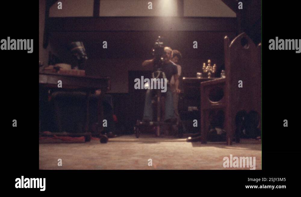 1970s: Low angle, men with movie camera, pushing camera on tracks. Men ...