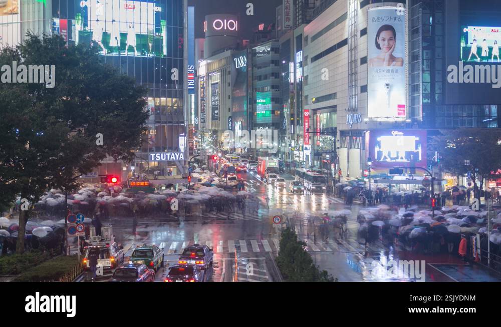 Tokyo Japan, night time lapse tourist with umbrella at Shibuya crossing ...