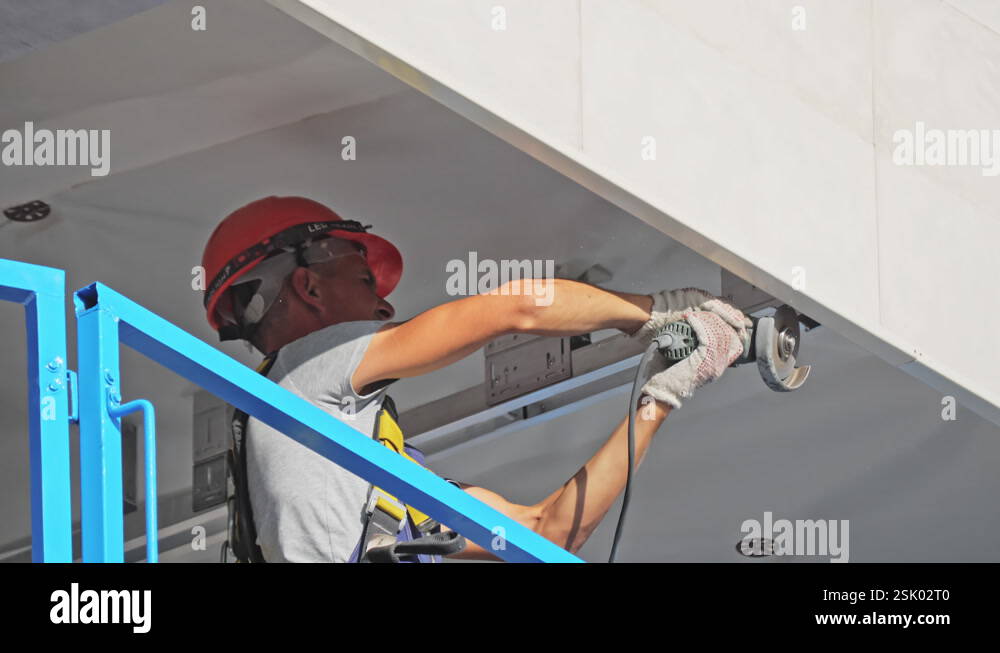 Worker with hardhat cuts metal beam edge with disc saw Stock Video ...