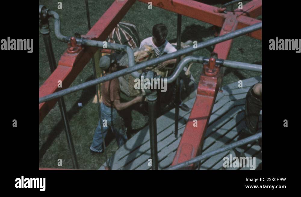 1950s: Men assemble carousel ride. Men carry wooden horses from truck ...