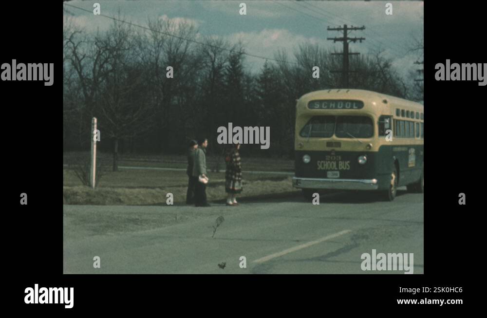 1960s: School bus pulls over, people get ready to board. Two people ...