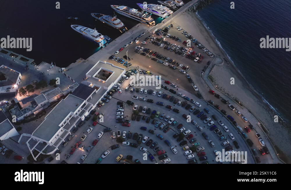 Mykonos greek island at night view of parking lot with cars and marina ...
