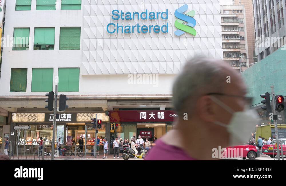 Chinese pedestrians walk through a zebra crossing in front of the ...