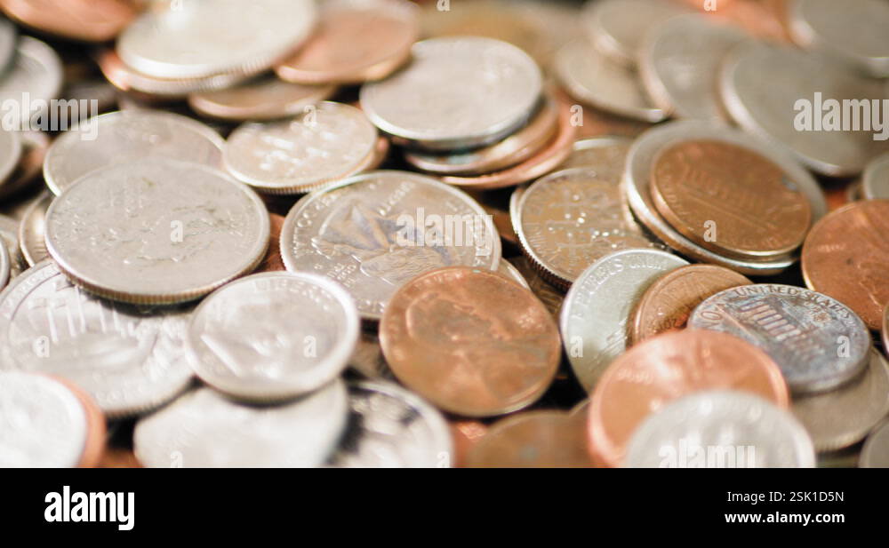 A pile of shiny assorted American coins, currency, money. Slider shot ...