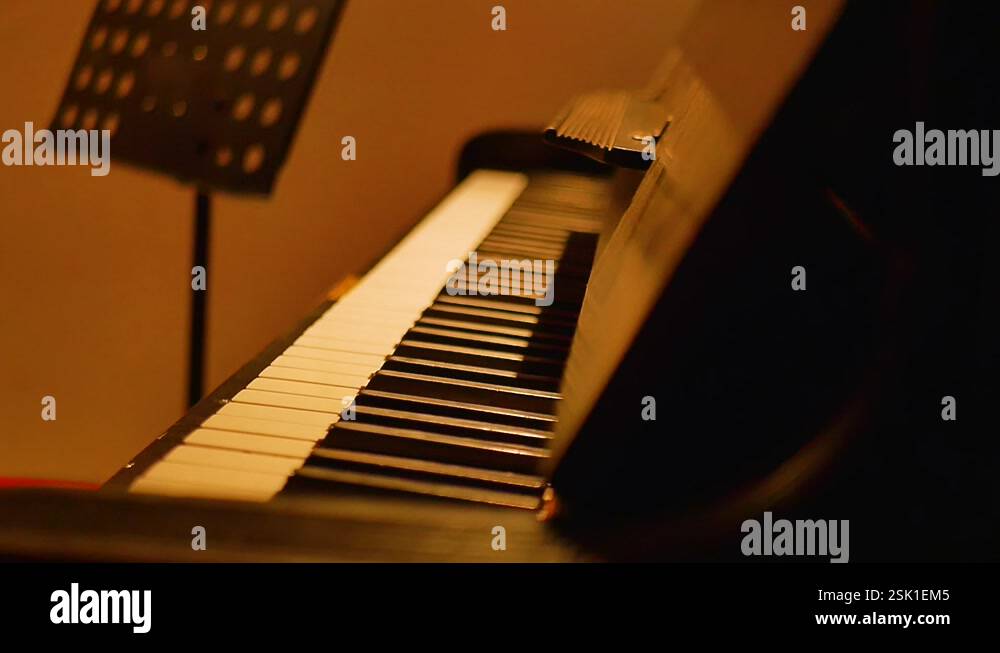 In a dramatic reveal shot, the camera slowly pans across a grand piano ...