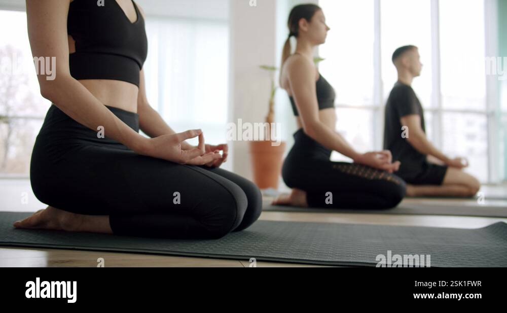 Relaxing after group exercises in class room. Yoga Club. Concentration ...