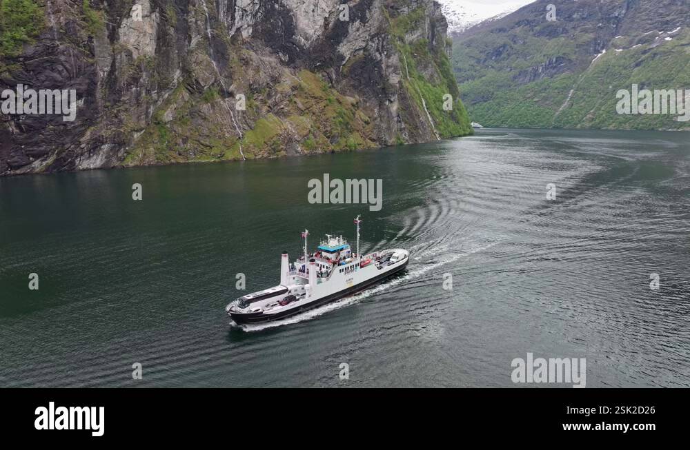 Car and tourist ferry full of people cruising in spectacular Geiranger ...