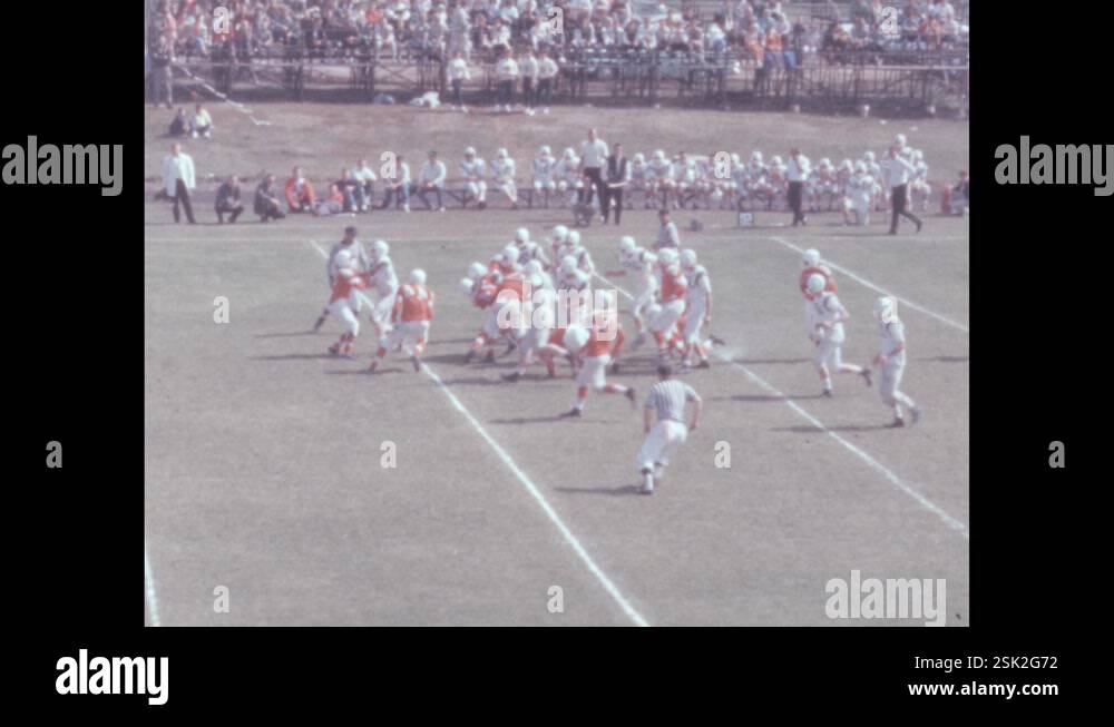 1950s: Football game. Two sides line up, ball is snapped and play is ...