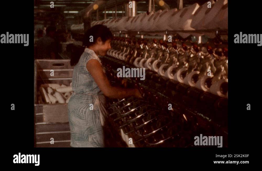 1960s: Woman runs threads around arms on automatic loom machinery in ...