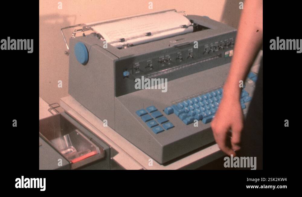 1960s: Man places stack of punch cards into feeder on computer near ...