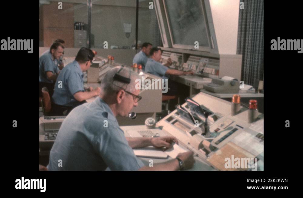 1960s: Men in headsets feed punch cards into computer consoles in ...