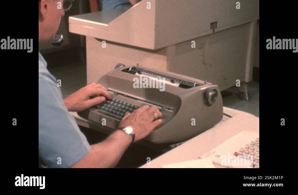 1960s: Man places punch card and paper into typewriter and types Stock ...