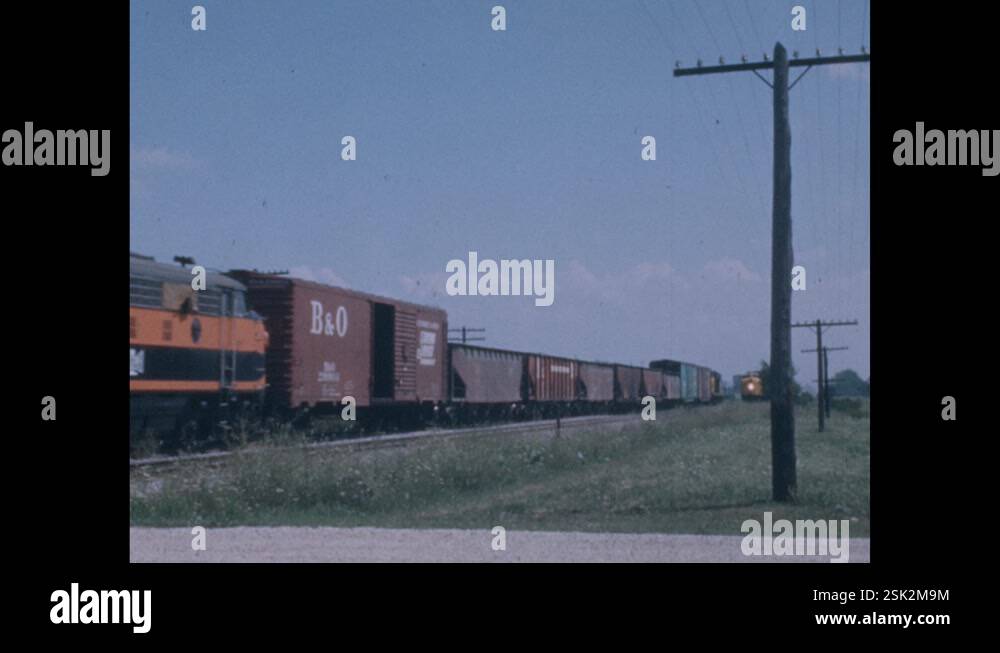 1960s: Cargo train travelling into the distance, another train passes ...