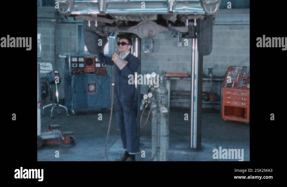 1960s: Mechanic working on a car with a torch Stock Video Footage - Alamy