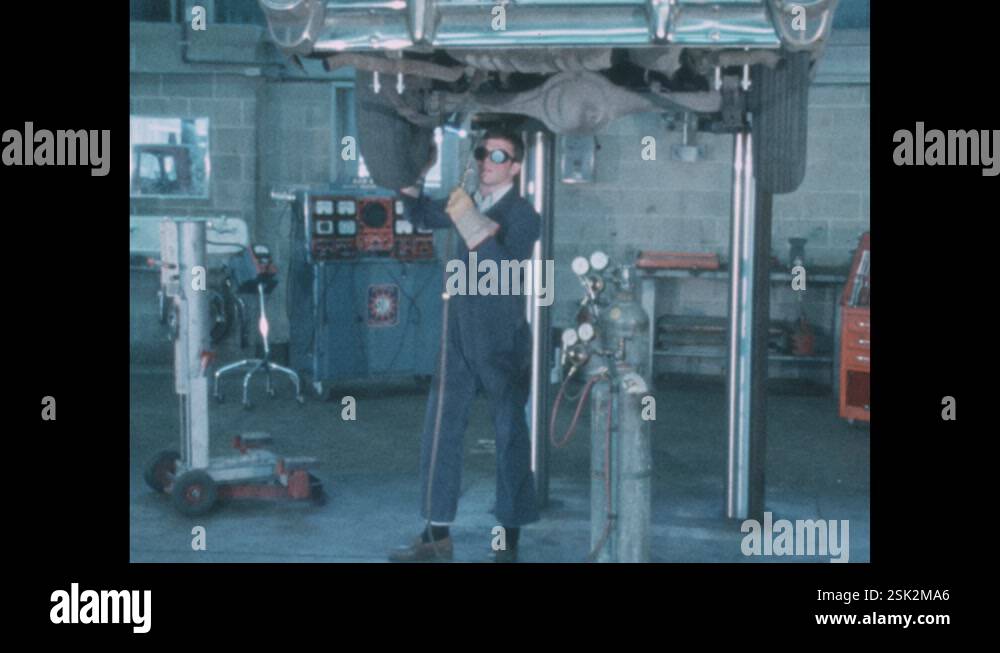 1960s: Mechanic using a torch on the car up on the lift Stock Video ...