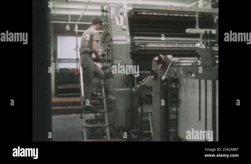 1960s: Man on a ladder working on a large printing machine Stock Video ...