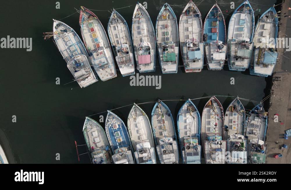 Flyover looks straight down onto fishing boat pattern in tight marina ...