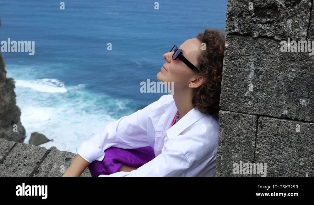 Woman tourist enjoys the amazing seascape of an ancient castle ...