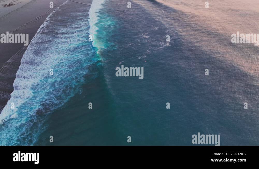 Drone clip tilting up showing rolling ocean waves and coral reef in ...