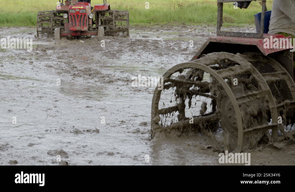 Indian farmers tractor working on the rice paddy fields in kerala south ...