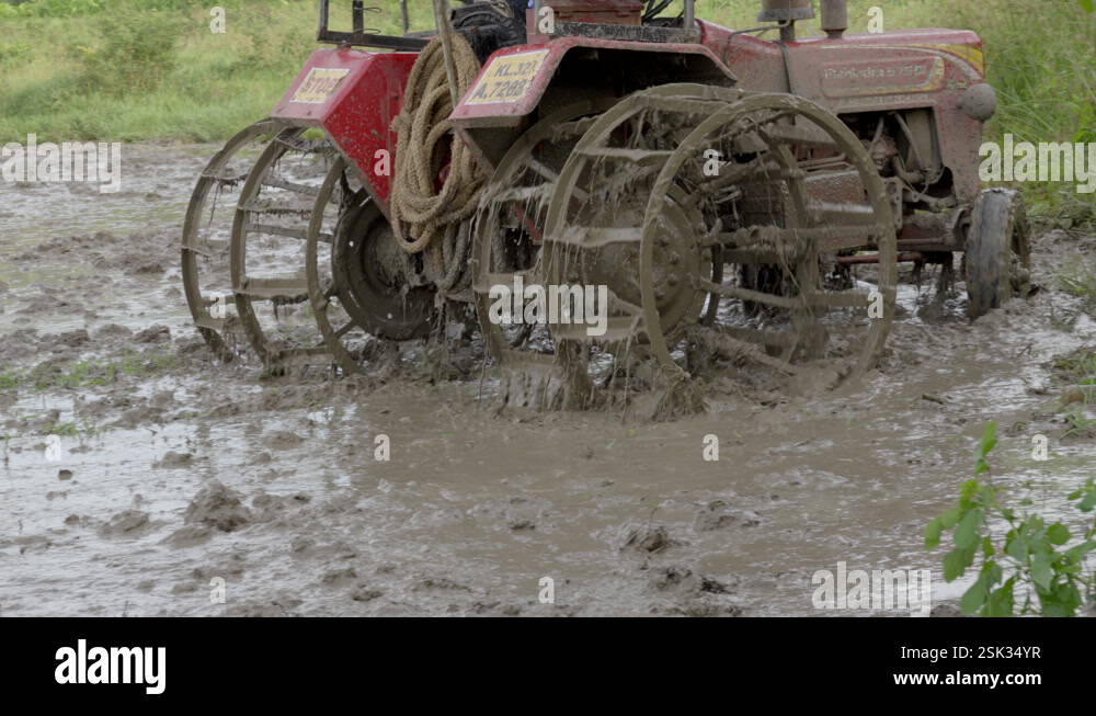 Indian farmers tractor working on the rice paddy fields in kerala south ...
