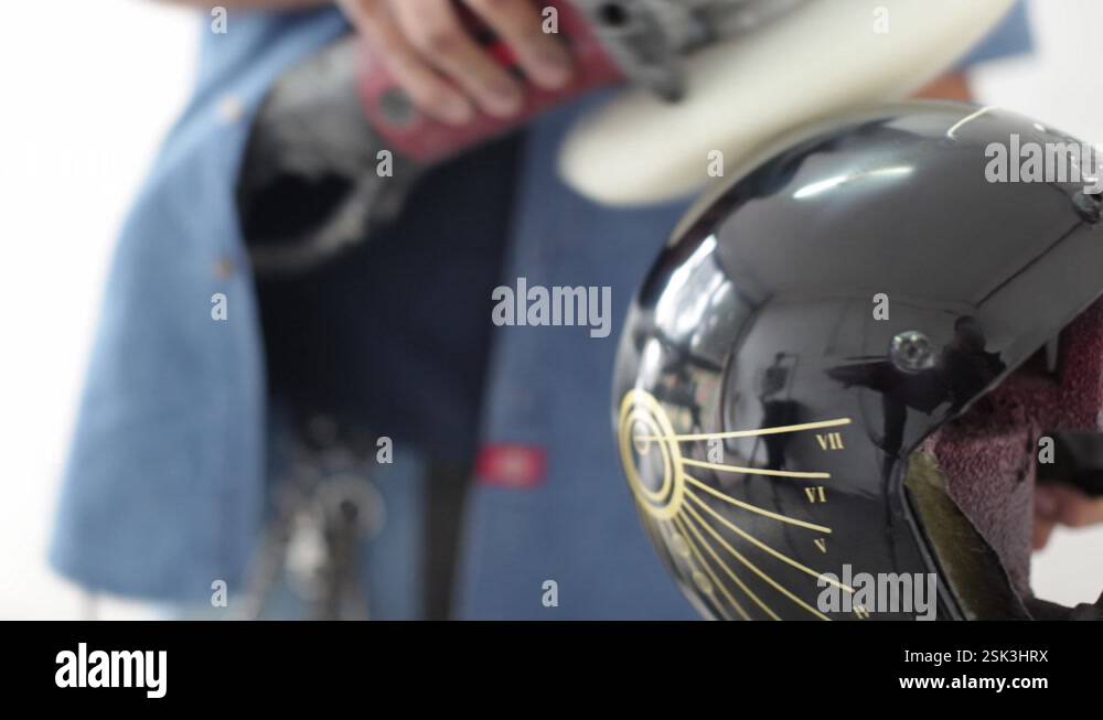 A custom-made motorcycle helmet is placed on a support and is being ...