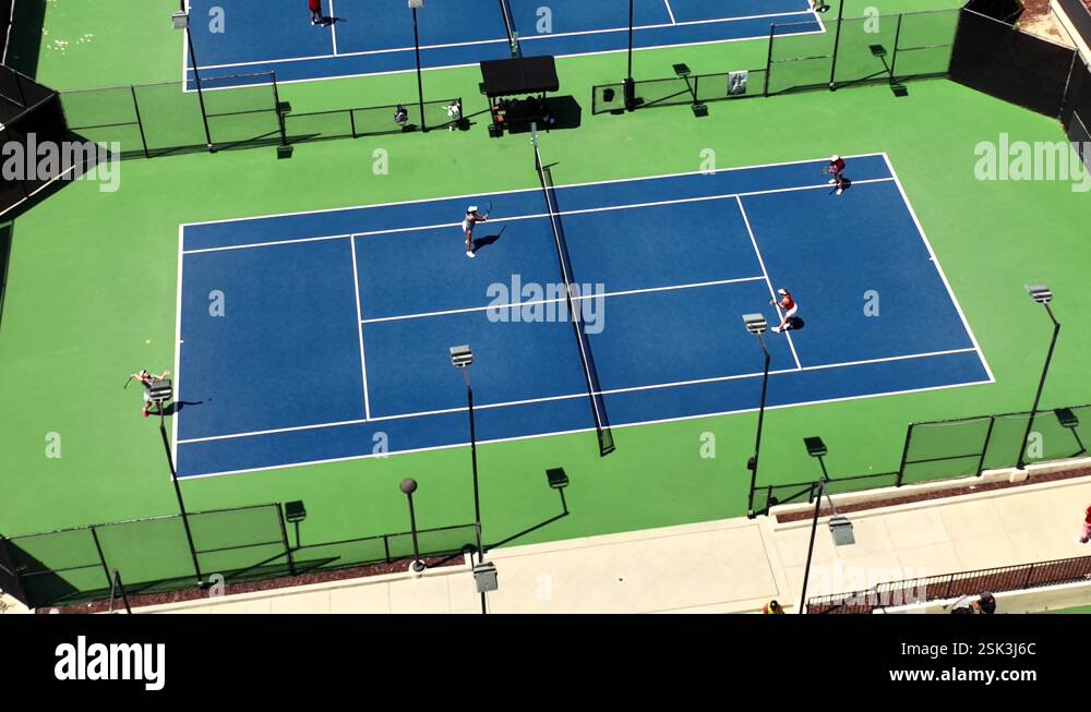 Women's tennis doubles match - aerial parallax of the blue and green ...