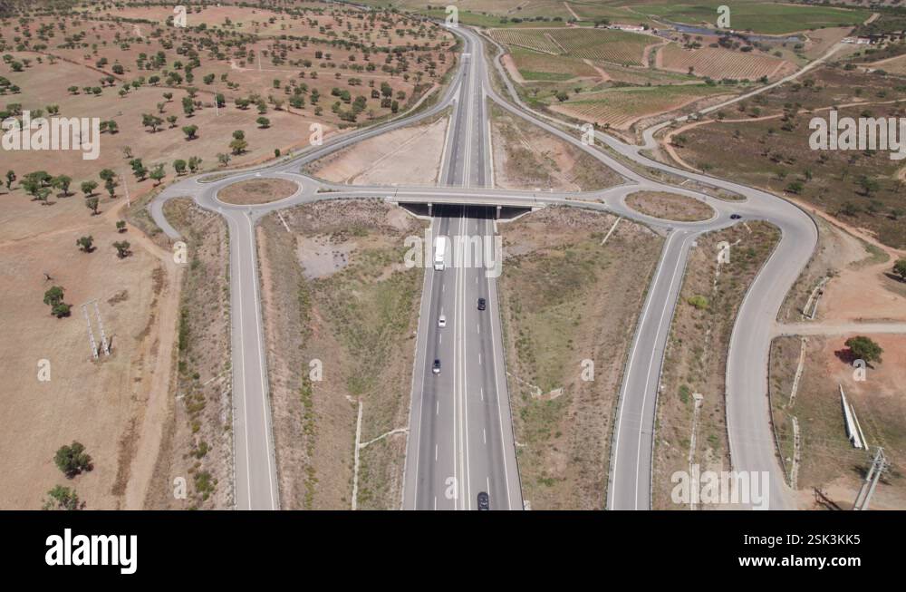 Aerial pull-out of highway with exits by dry landscape in Portugal ...