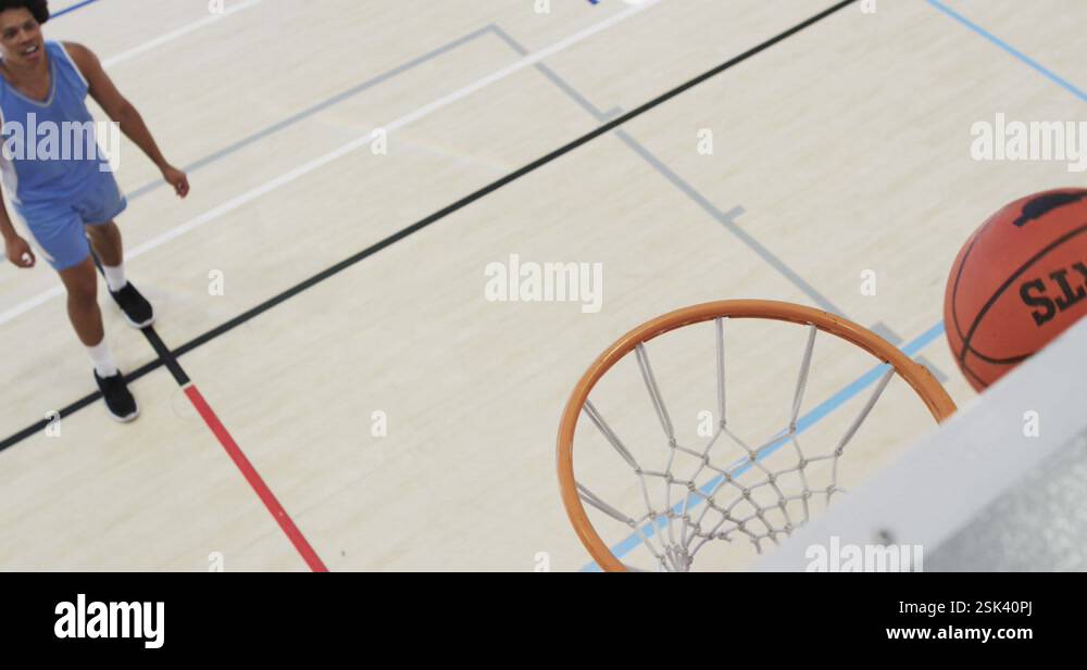 High angle of diverse male basketball team training at indoor court and ...