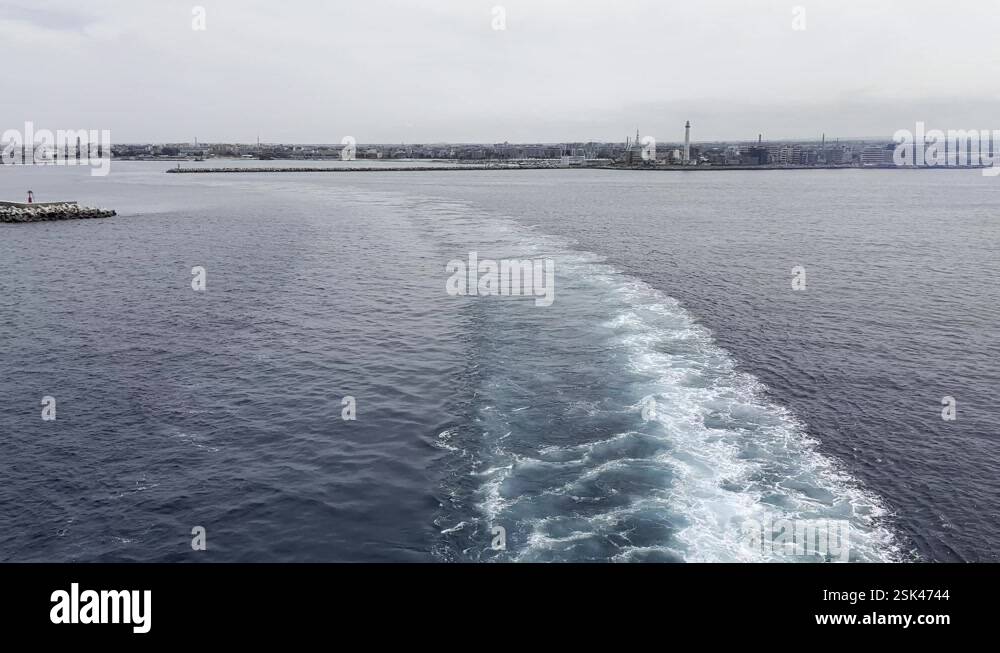Wake make tracks in the sea. A large ship leaves the port of Bari. In ...