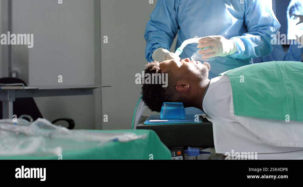 African american male surgeon giving anesthesia to patient in operating ...