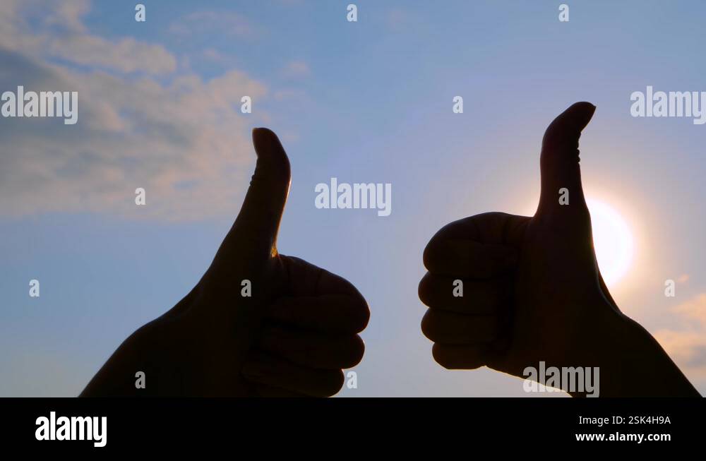 Silhouette of woman is showing two hands with thumbs up gesture - sun ...
