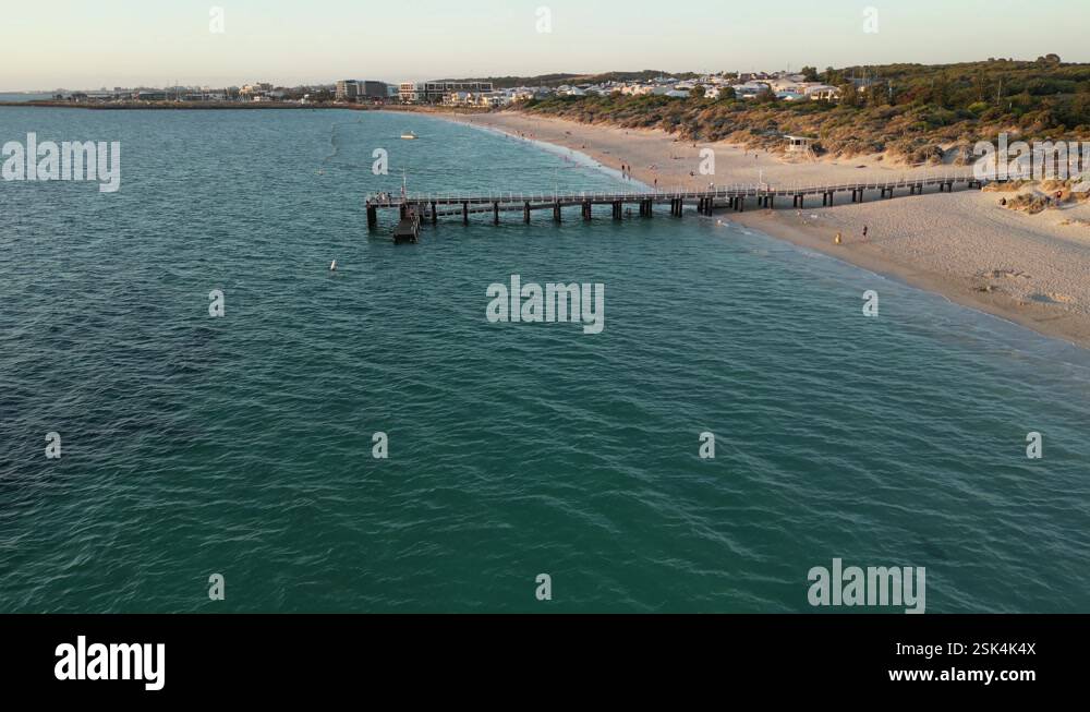 Drone shot of Coogee beach with walking people during beautiful sunset ...
