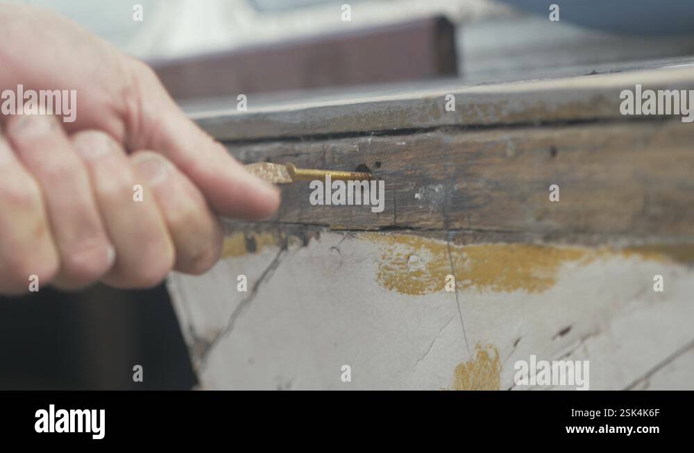 Securing a brass screw into a wooden boats inner gunwale Stock Video ...
