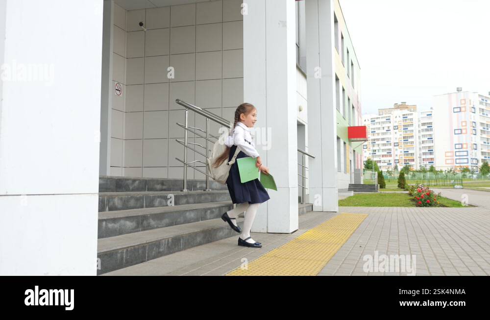 Junior schoolgirl running from school throws away copybooks Stock Video ...