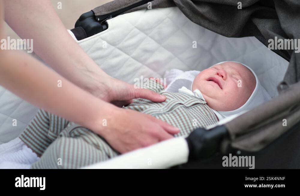 Mom tries to calm her crying baby, hugging and soothing her crying son ...