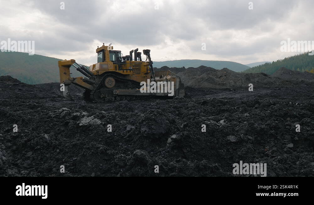 Heavy industrial machinery driving on the dirt at the huge open-pit ...