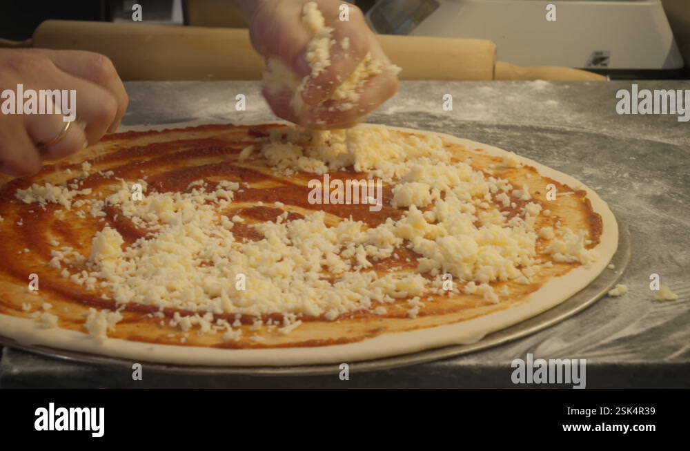 Chef Sprinkles Freshly Grated Parmesan Cheese On A Tomato Sauced Dough ...
