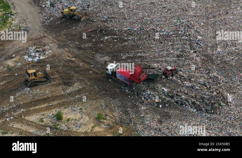 Garbage truck with tractor and bulldozer on the landfill site pile ...