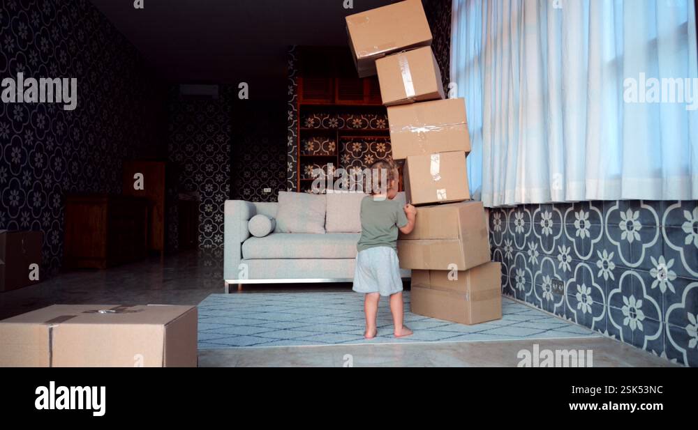 Young boy touch empty box and whole tower collapse, slow motion shot ...