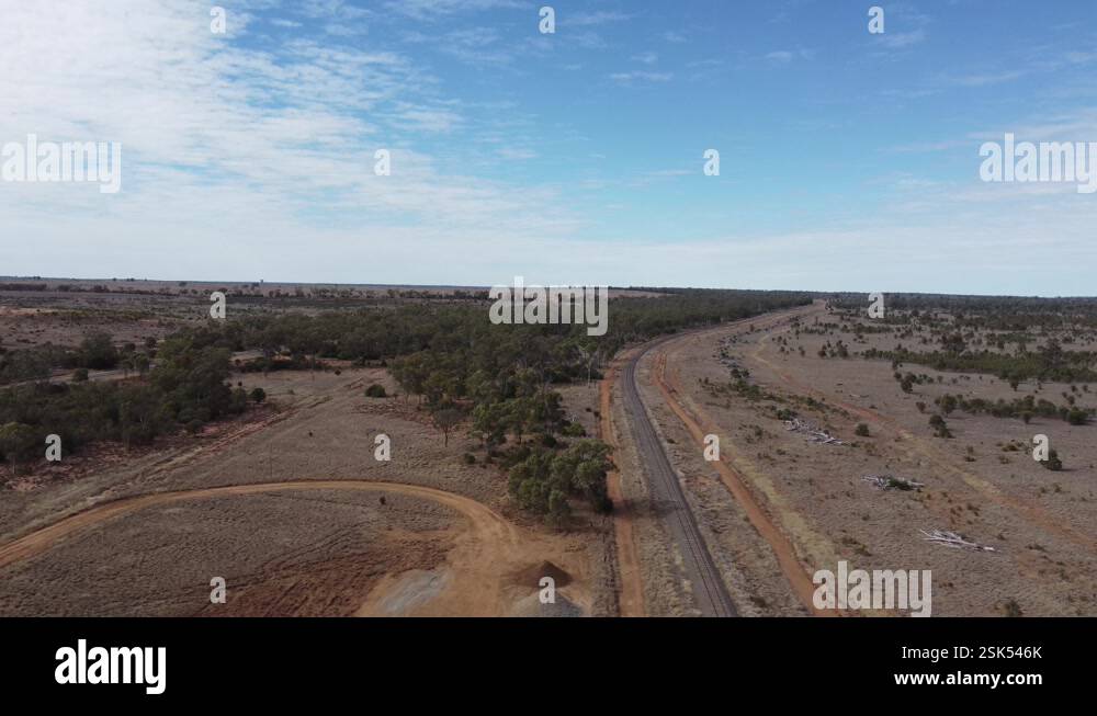 Drone flying over unsealed roads and a railway line in a desert style ...