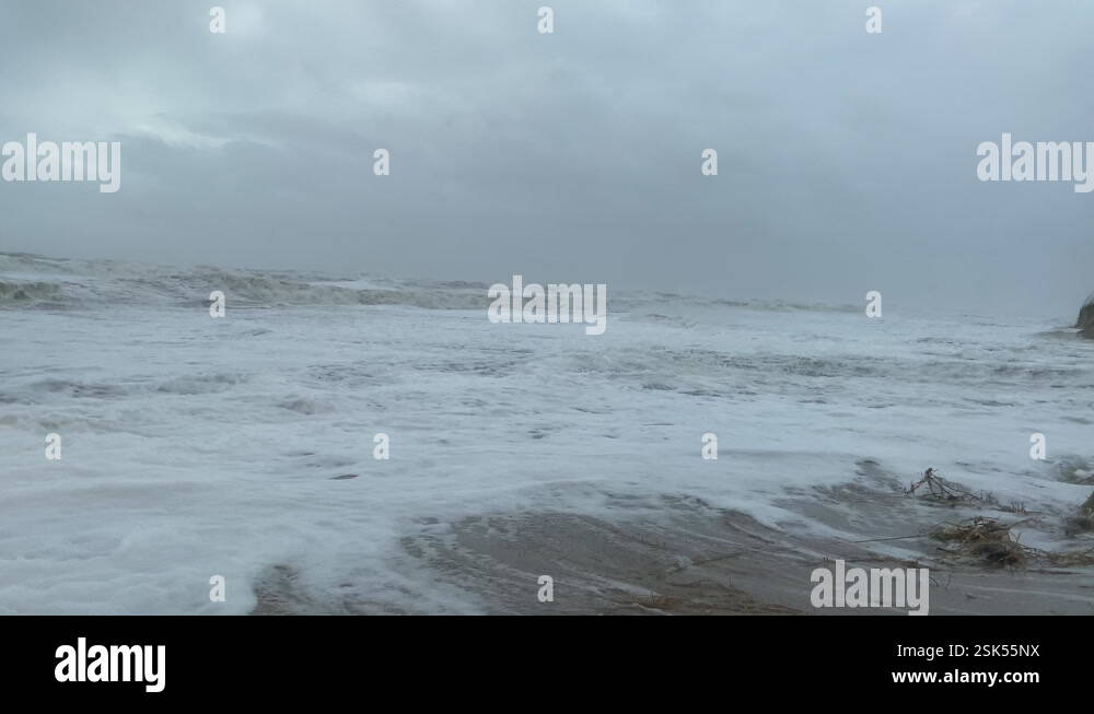 Waves crash against sand dunes and flood beach from hurricane surge ...