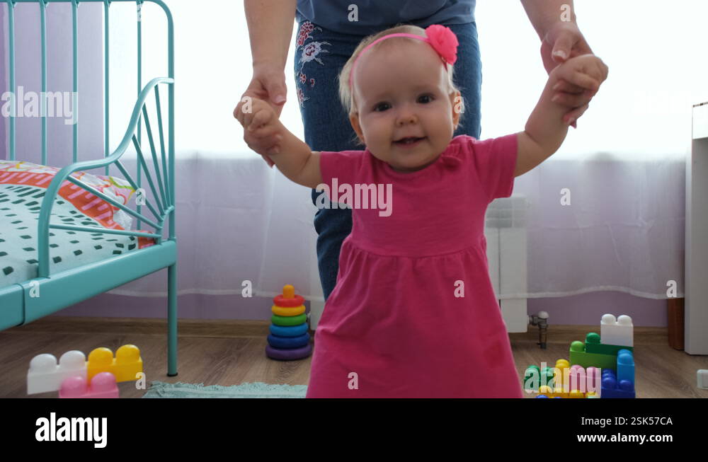 Baby girl learning walking with help of mother Stock Video Footage - Alamy