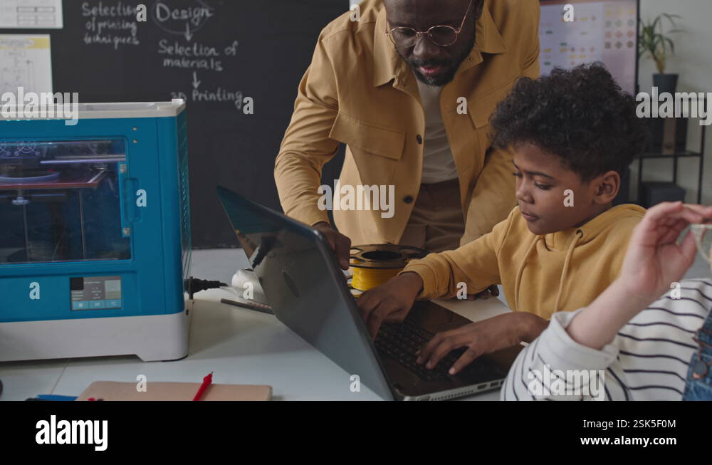 Teacher Helping Children with Coding on Laptops on 3D Printing Class ...