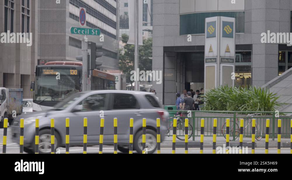 Wide shot: Static camera captures a busy street with cars passing from ...