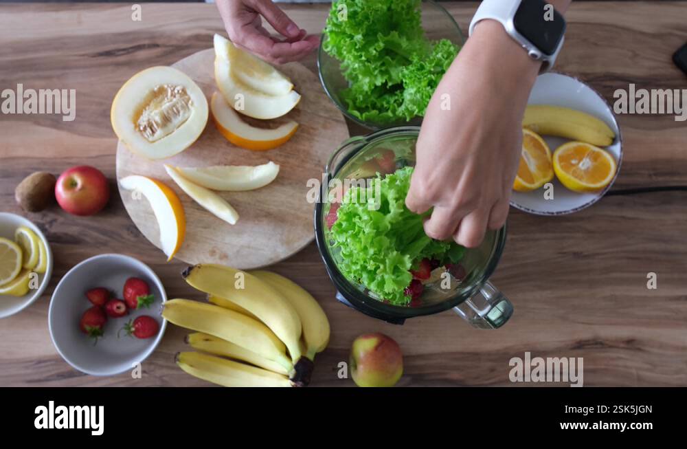 Womans hand cut and put fruits and berries into mixer Stock Video ...