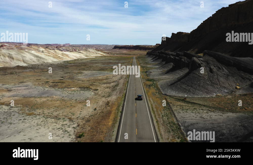 Aerial view following a car driving on a scenic road, sunny day in ...